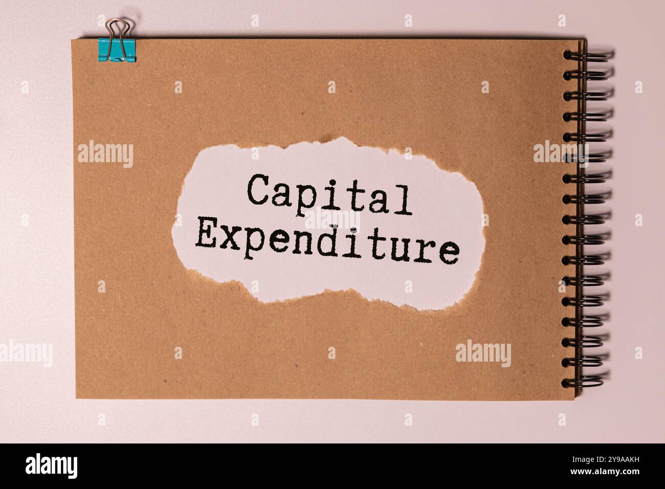The text Capital Expenditures behind torn brown paper Stock Photo - Alamy