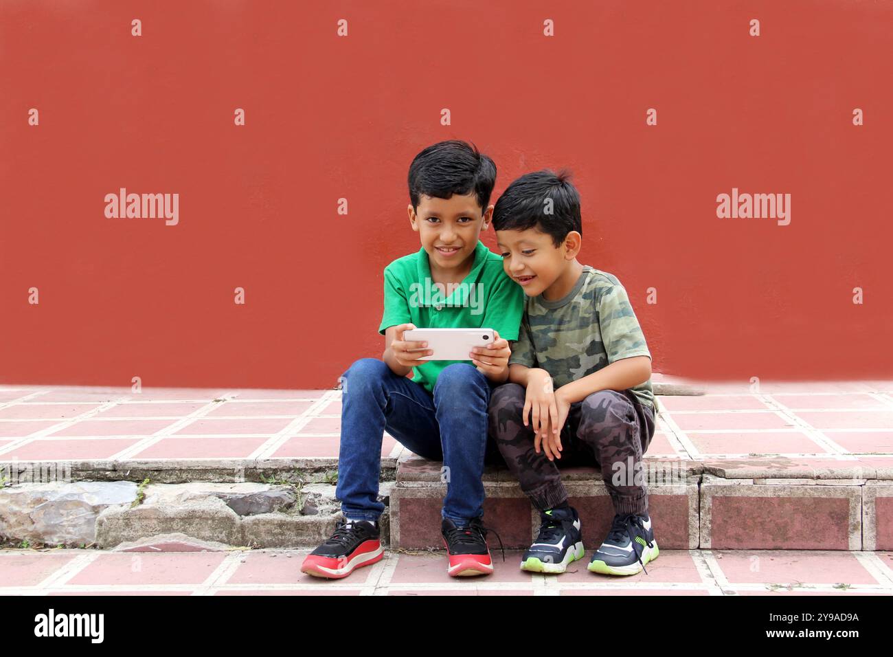 Two dark-haired Latino children who are brothers or friends who live in ...