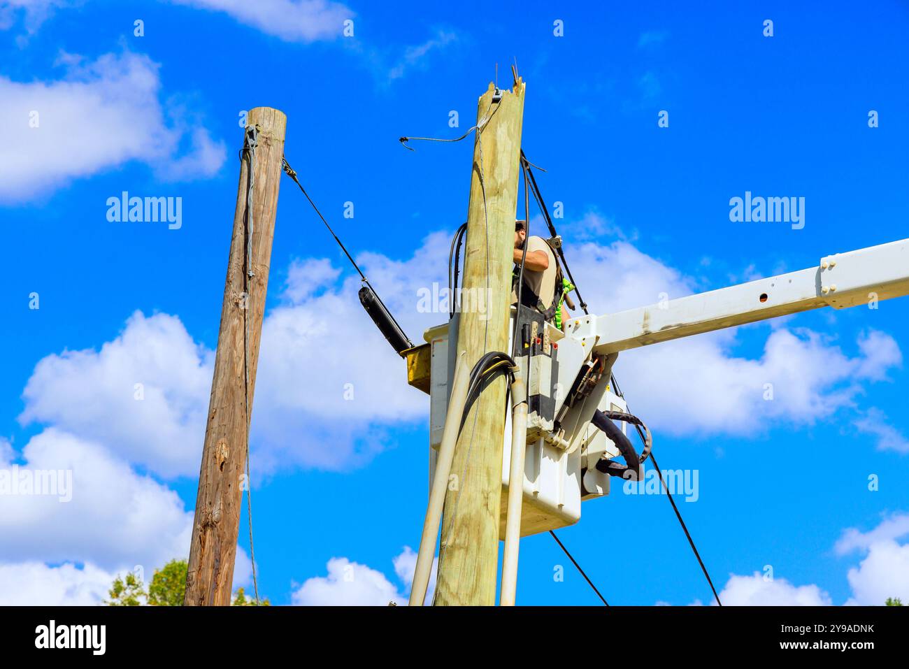 Electrician working on electric power system after hurricane using ...