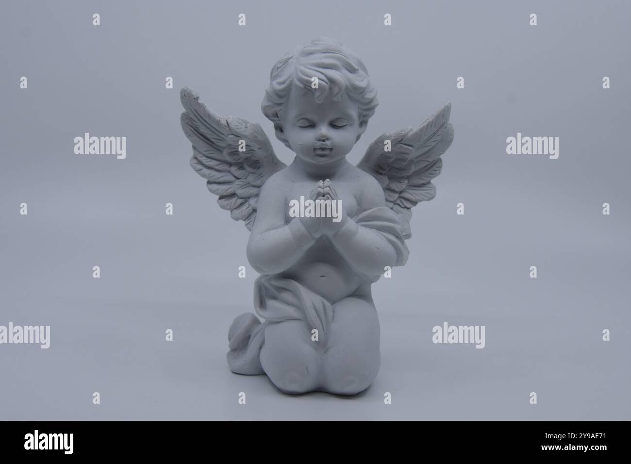 An exquisite statue depicting a serene angel kneeling down gracefully ...