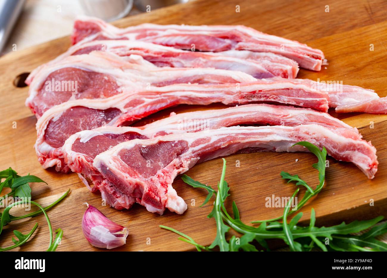 Raw mutton chops on wooden cutting board with herbs and spices Stock ...