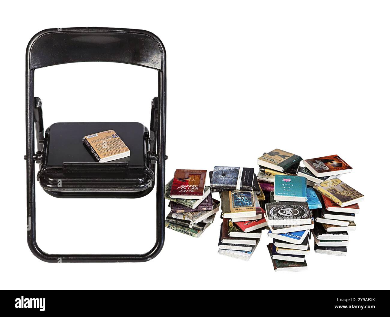 Black Folding chairs for easy seating for groups with a stack of books ...
