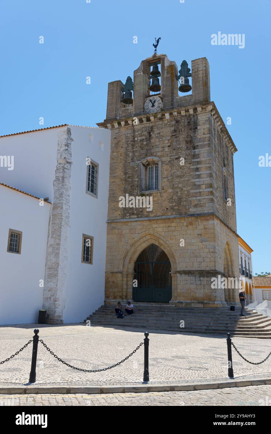 Historic church with bell tower, surrounded by white buildings, under a ...