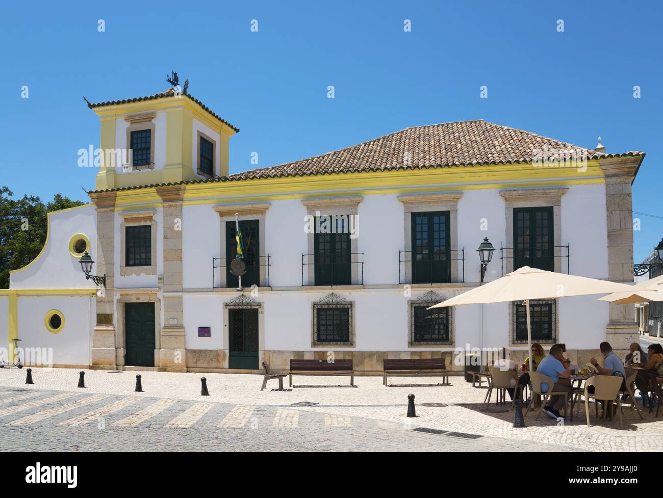 Colonial-style building with yellow accents, outdoor seating under ...