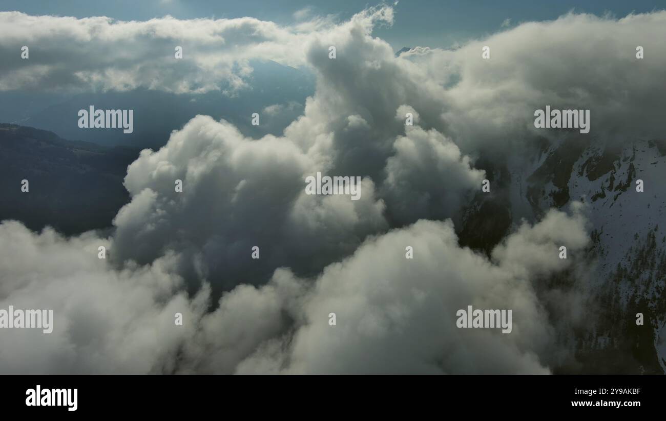 Flying through beautiful white fluffy clouds between high rocky ...