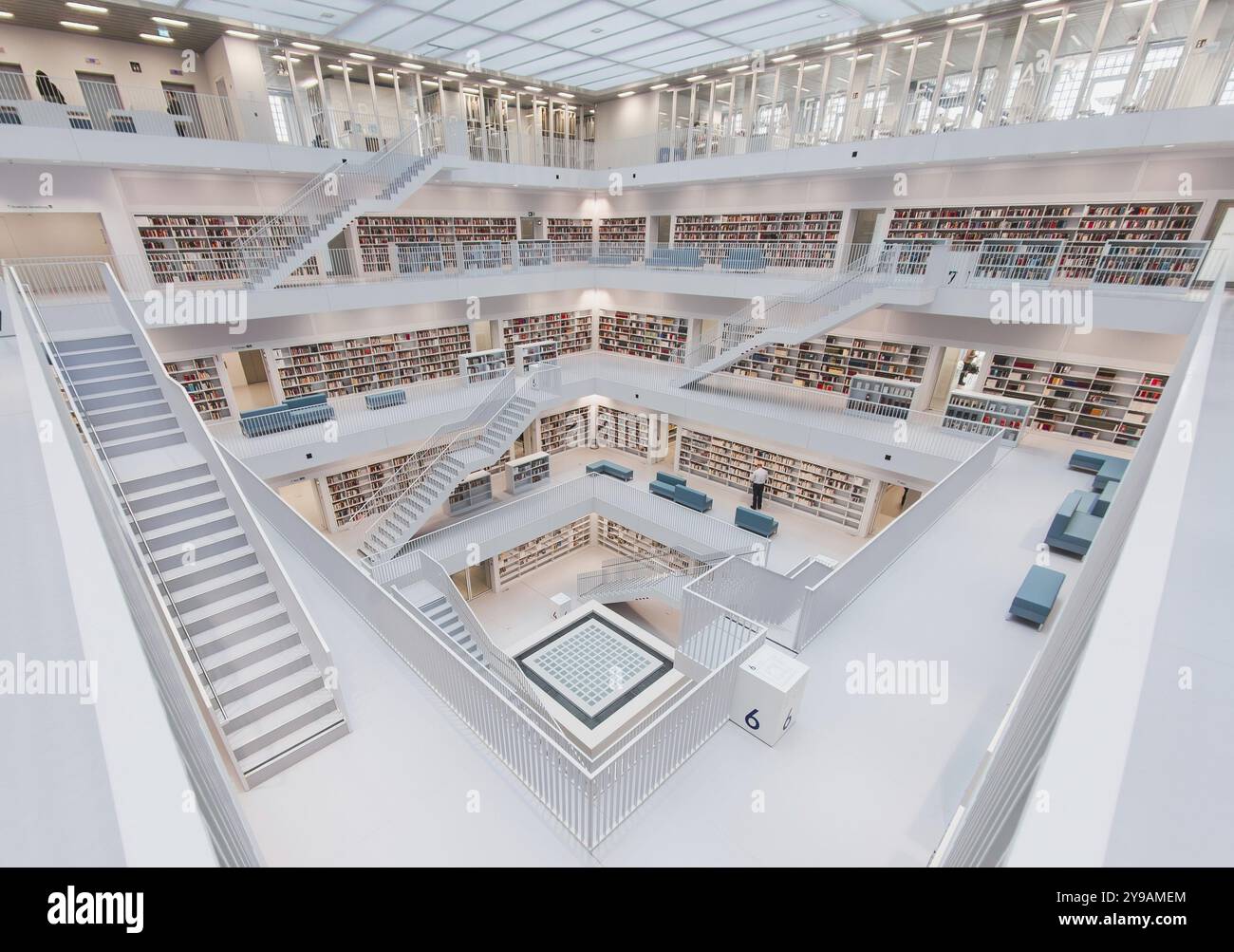 Modern, bright library with open staircases and many bookshelves in a ...