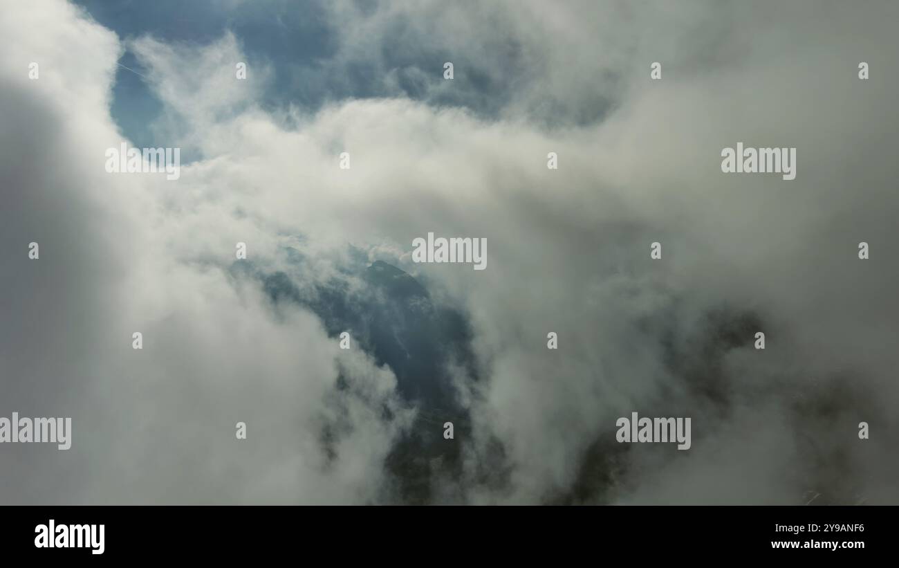 Flying through beautiful white fluffy clouds between high rocky ...