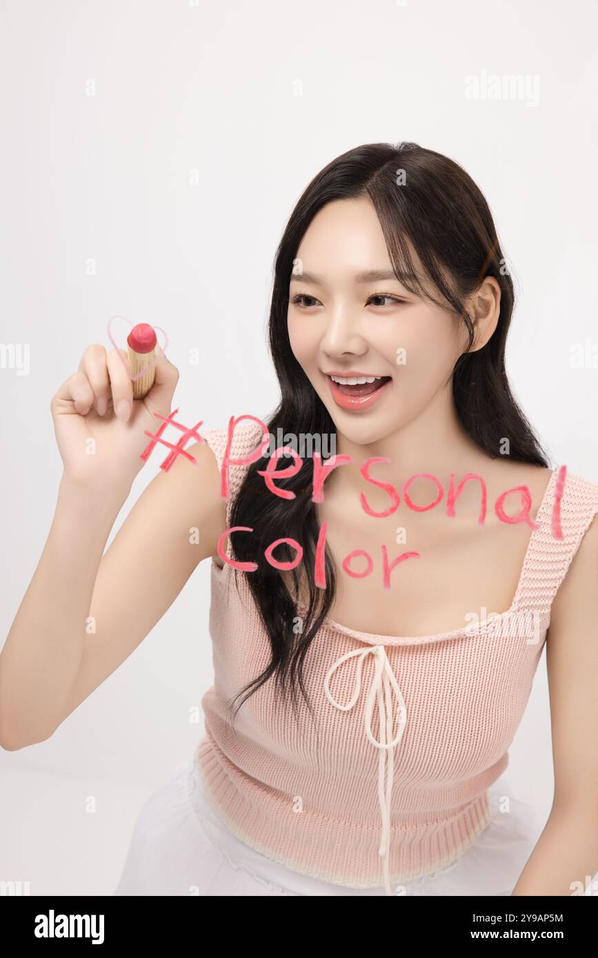 A woman in her 20s writing on a transparent wall with lipstick Stock ...