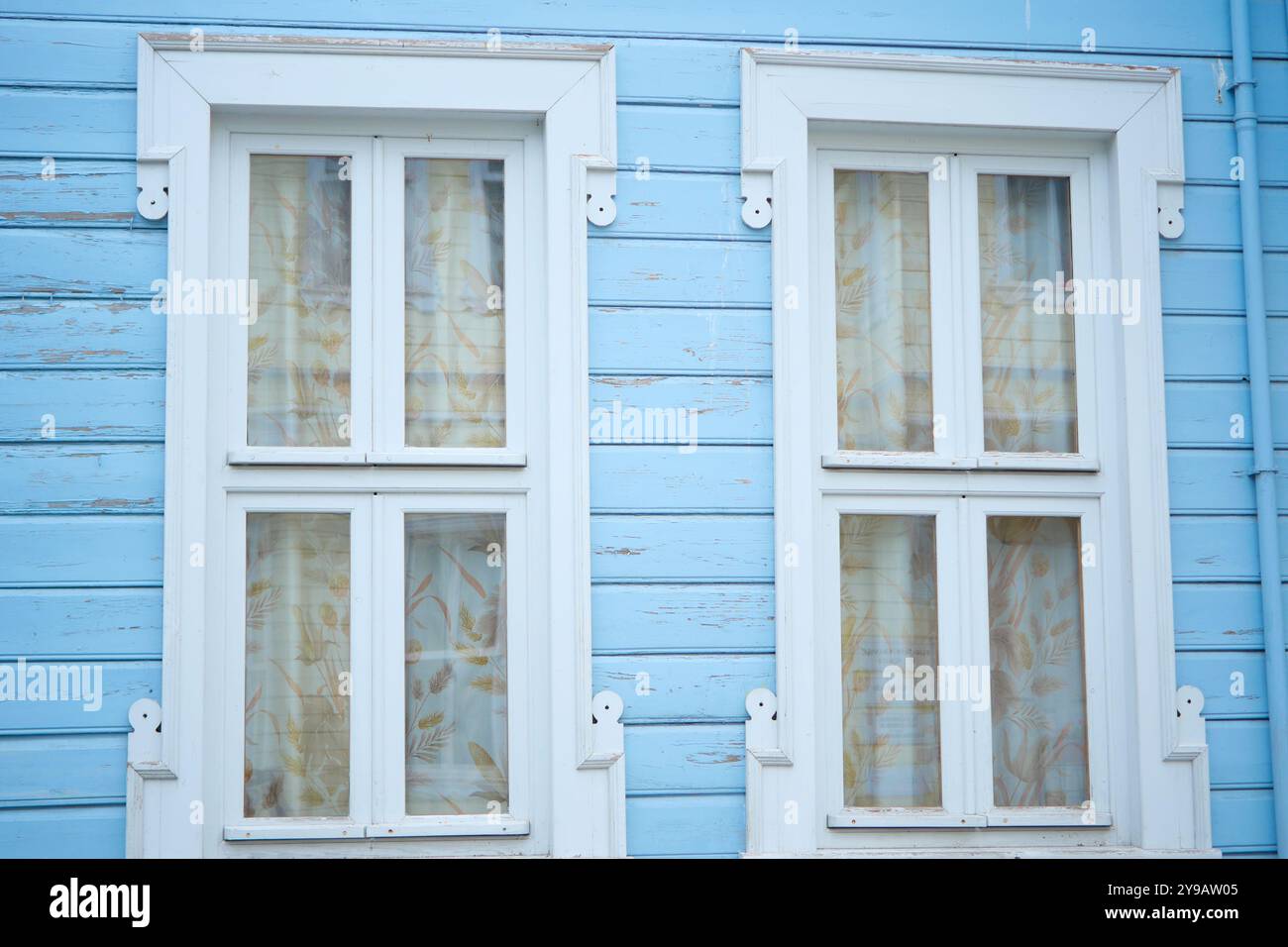 A Charming Blue Wooden House Featuring Beautifully Designed Windows ...