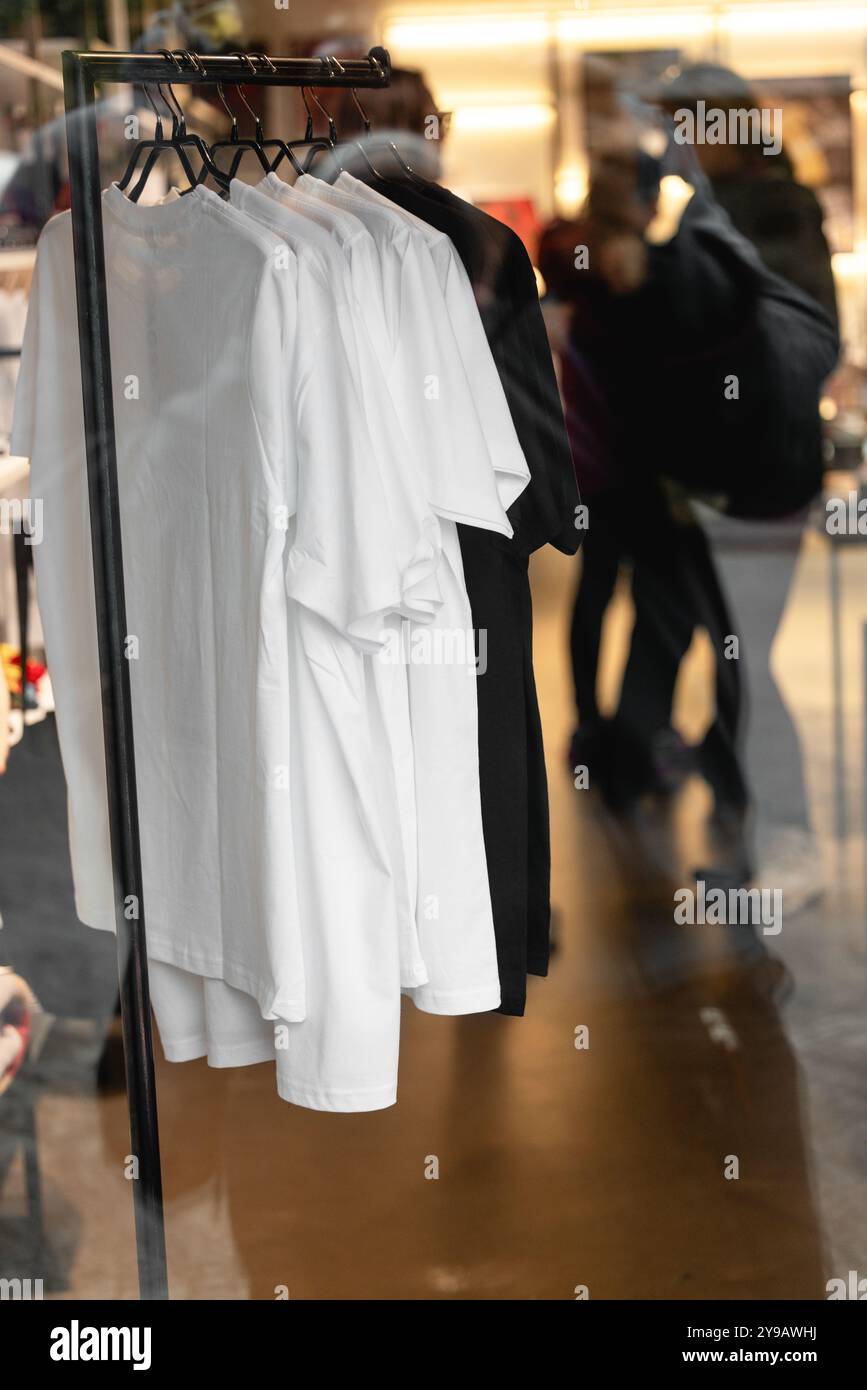 Clothes on hangers in a retail shop T-shirts display window Stock Photo ...