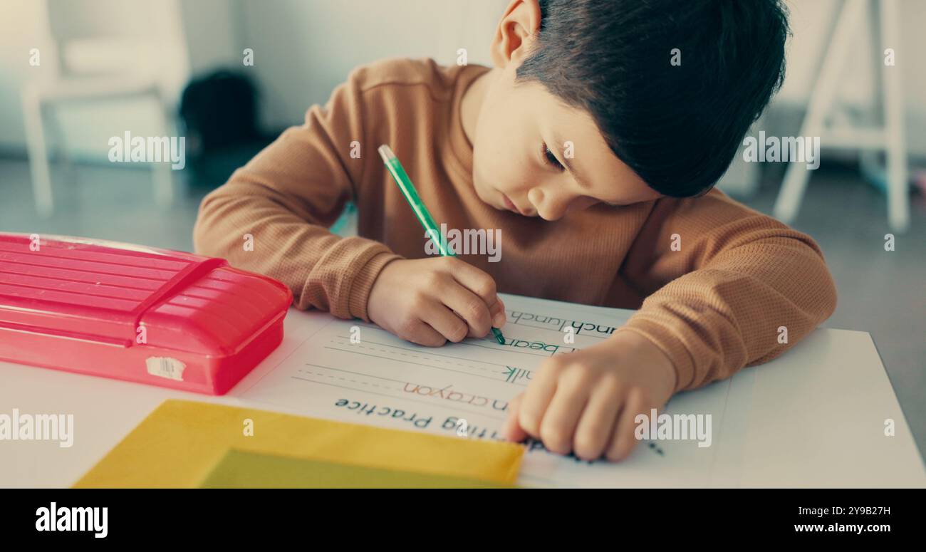 Boy, child and writing with paper at school for education, learning and ...