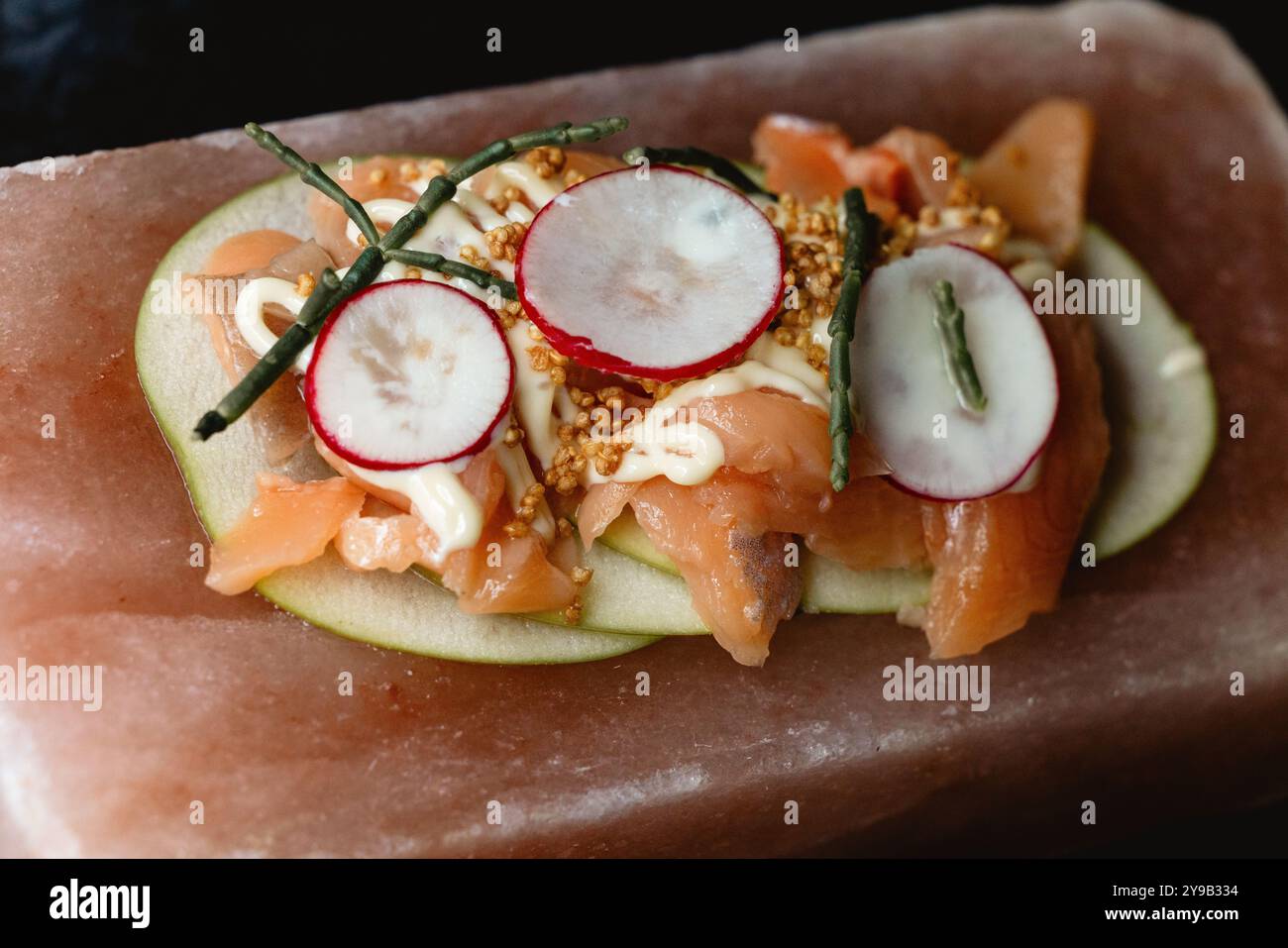Presentation of fresh fish on a pink Himalayan salt block, served with ...