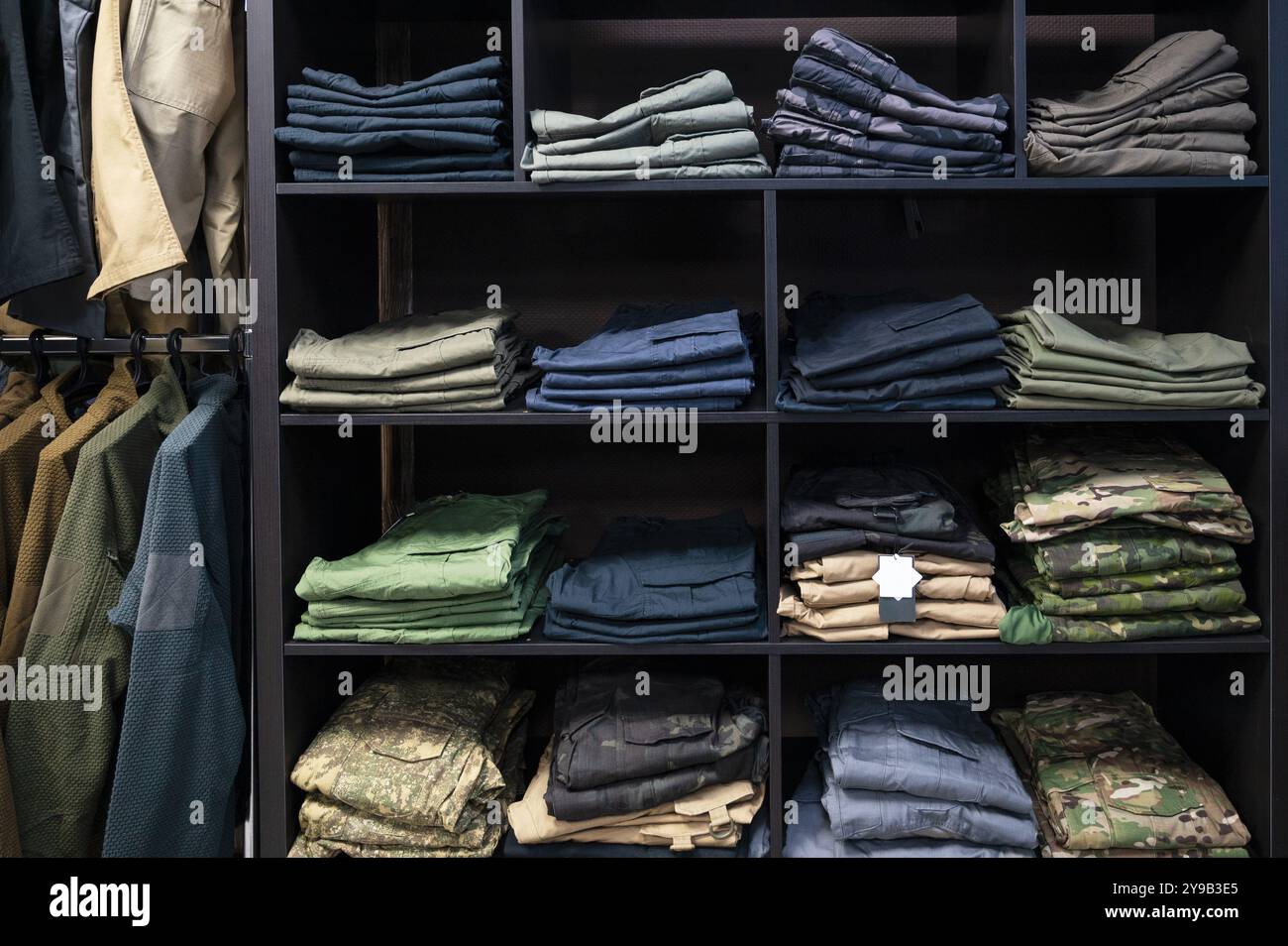 Stacked tactical pants and military uniforms, including camouflage and ...