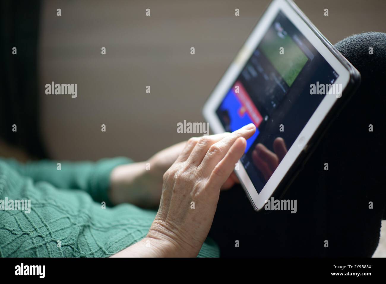 An older woman concentrated on reading from her tablet Stock Photo - Alamy