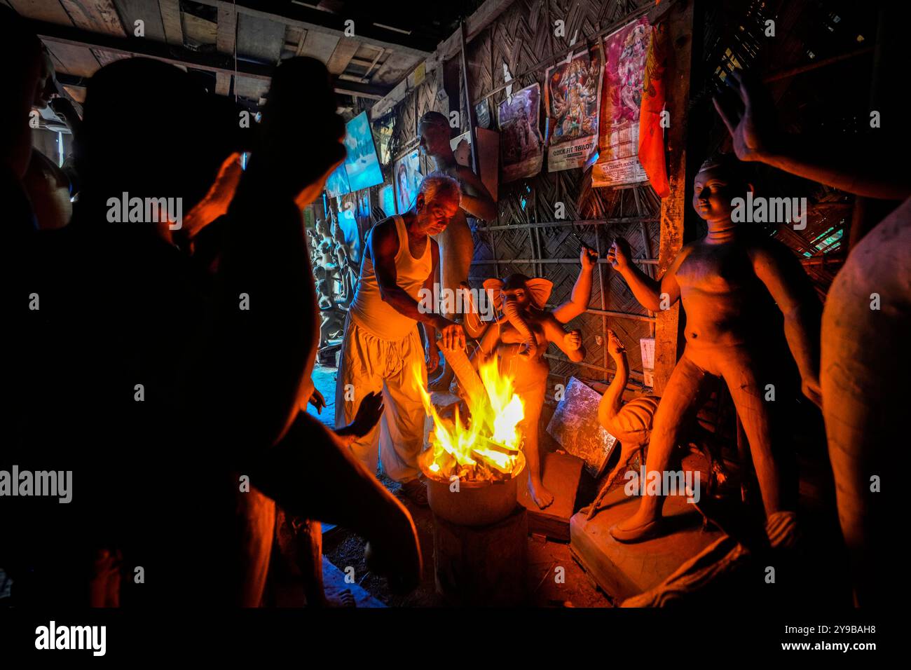 Ratan Paul, 70, lights a wood fire to dry mud idols of the Hindu gods ...