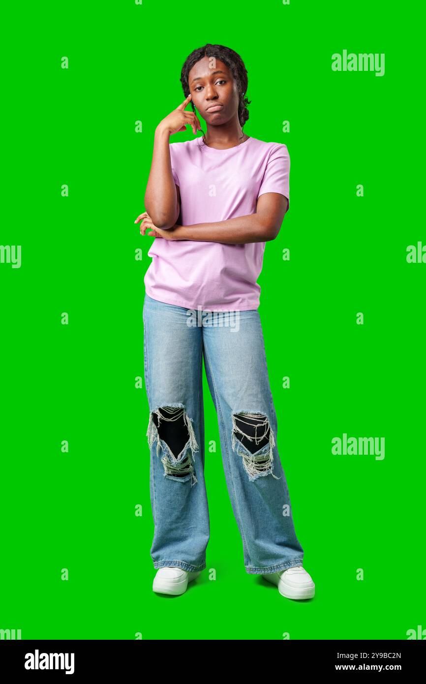 Thoughtful woman pondering in front of a bright green background during ...