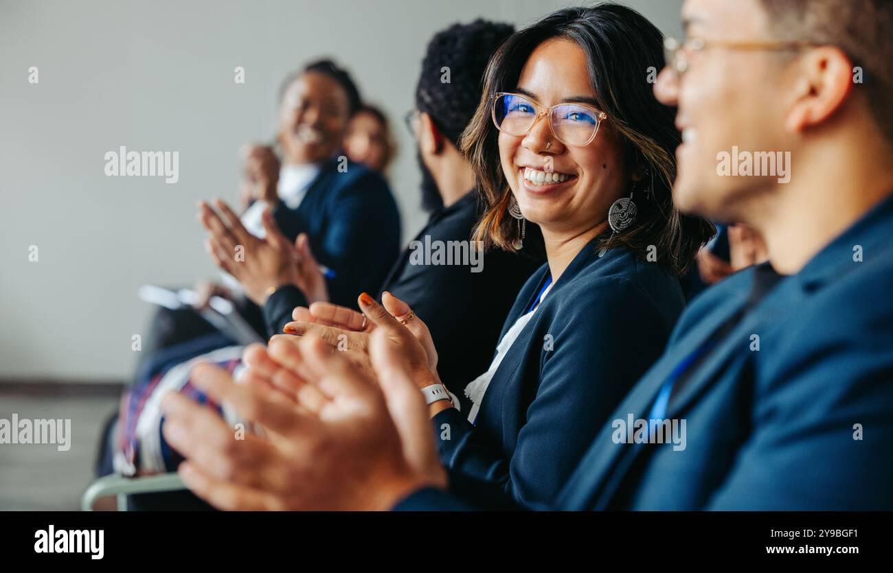 Group of diverse colleagues clapping and smiling happily during a ...