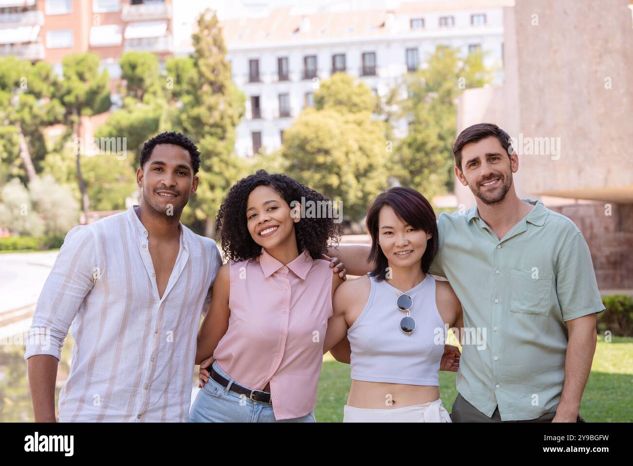 Four friends are posing with their arms around each other while ...