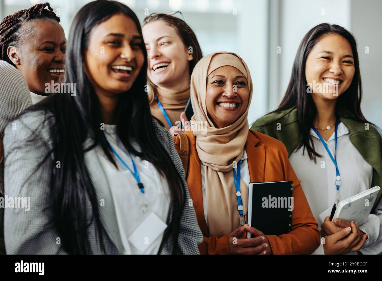Diverse group of women in business attire, smiling and interacting ...