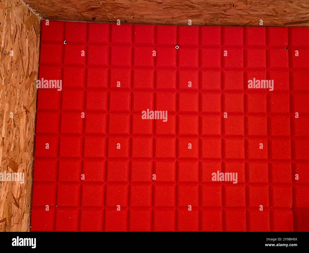 Vibrant red acoustic paneling against wood creates a striking visual ...