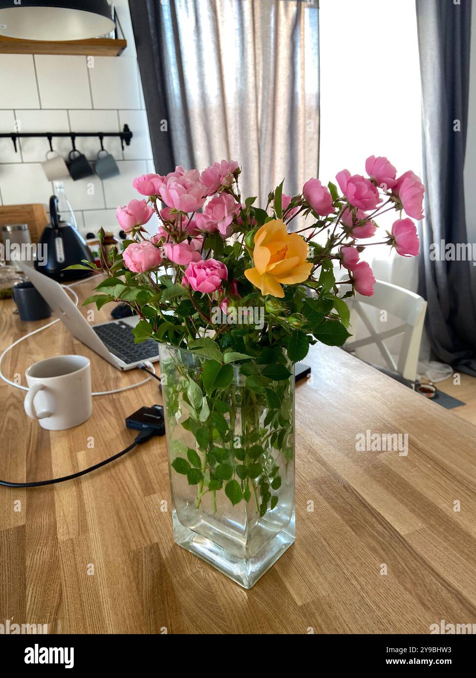 Bouquet of pink and yellow roses in a glass vase adds a touch of ...