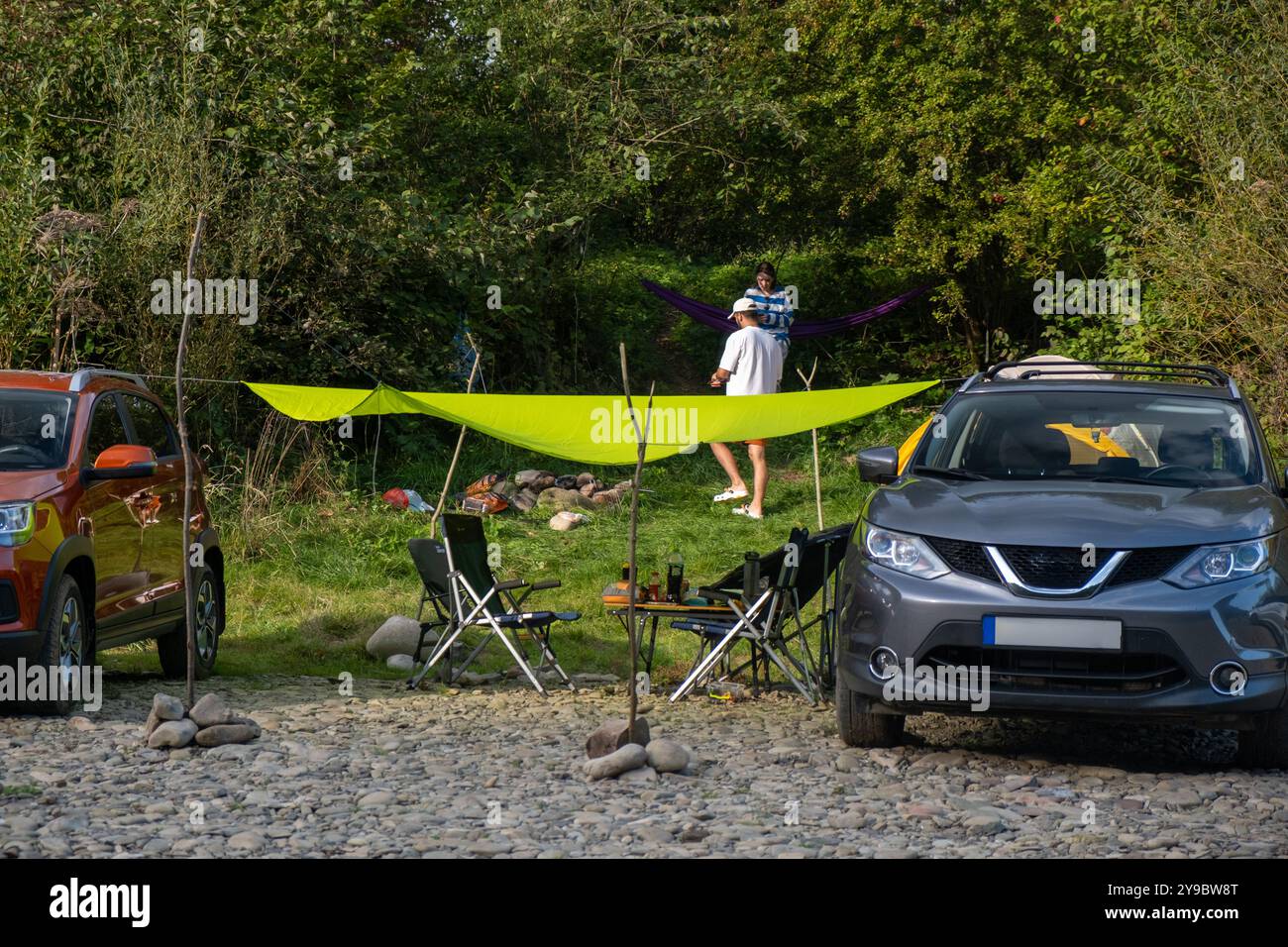 Camping Setup by the Riverbank with Cars Stock Photo - Alamy