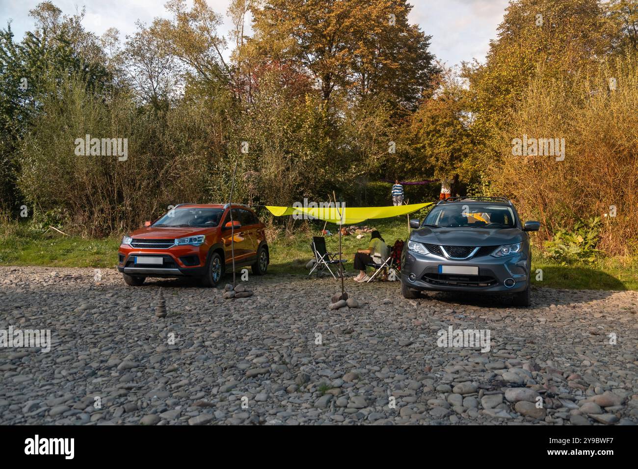 Camping Setup by the Riverbank with Cars Stock Photo - Alamy