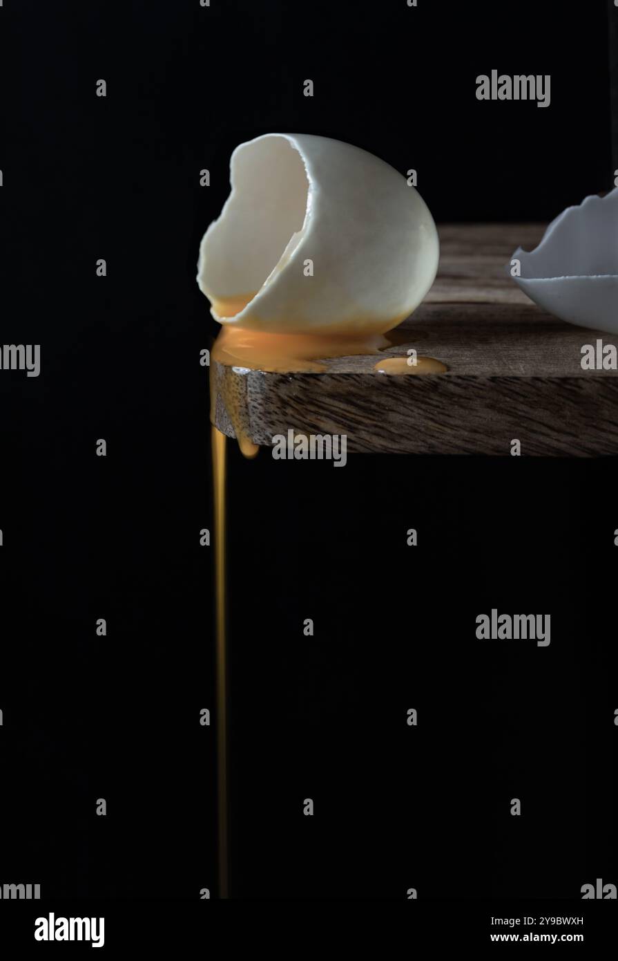 Conceptual image of a broken white eggshell with dripping egg yolk on ...