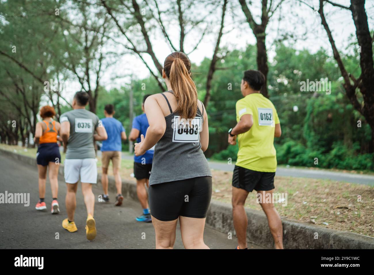 back view marathon participant running at outdoor track Stock Photo - Alamy