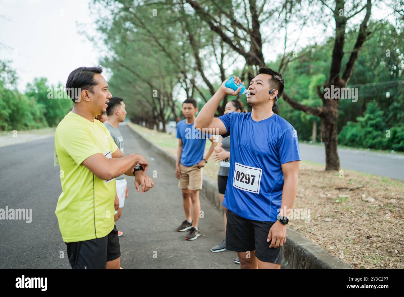 asian runners taking break and drinking water Stock Photo - Alamy