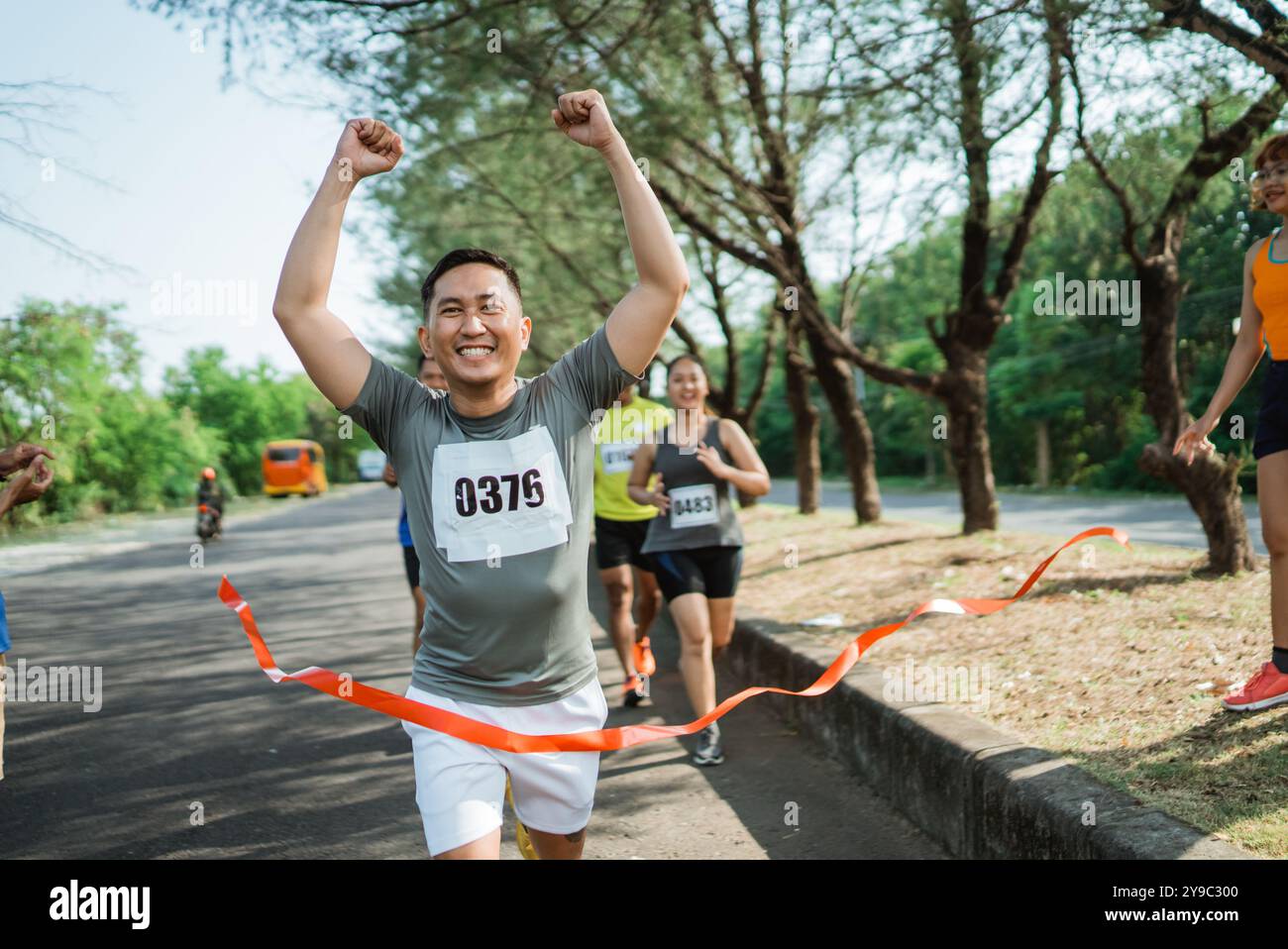 marathon runner crossing finish line with hands up gesture Stock Photo ...