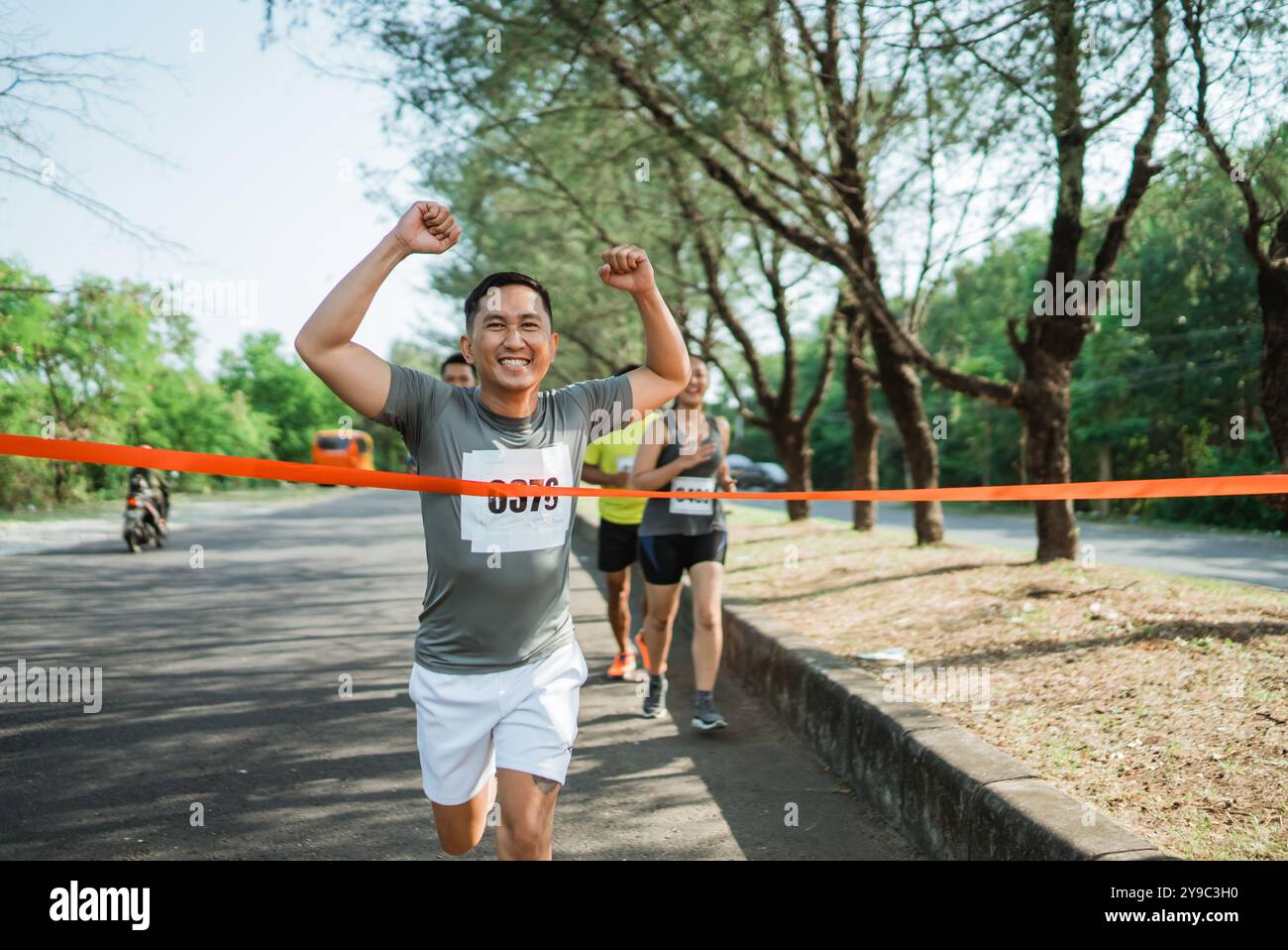 asian runner almost crossing finish line Stock Photo - Alamy