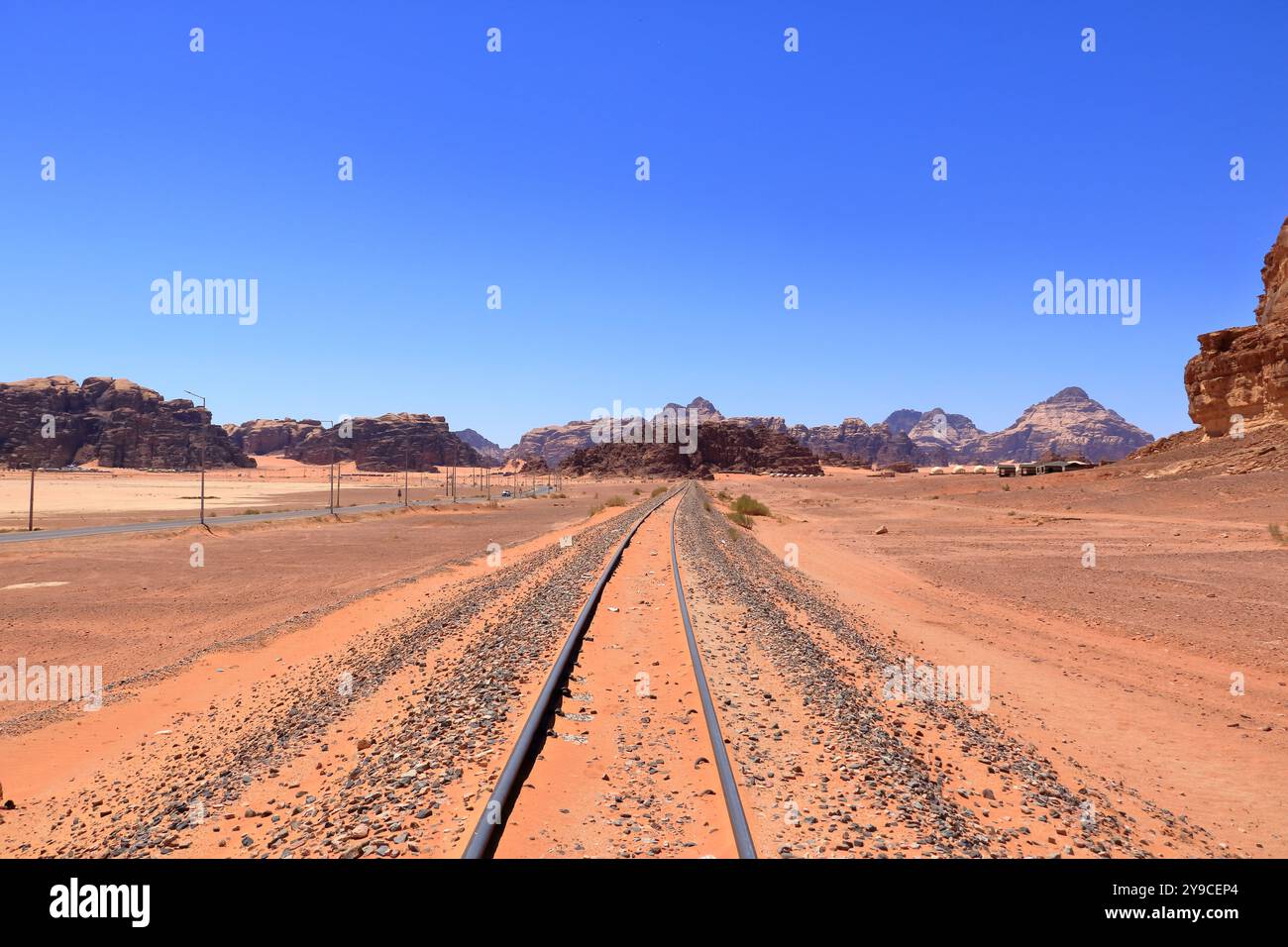 Old train rails almost completely covered with desert sand in Wadi Rum ...