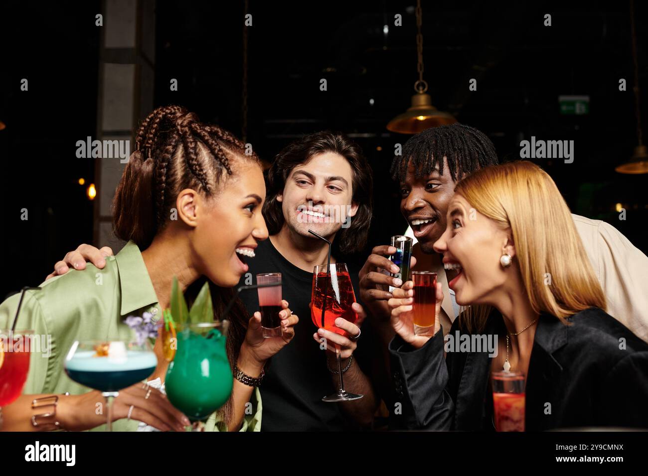 A group of diverse colleagues share laughter and cocktails at a vibrant ...