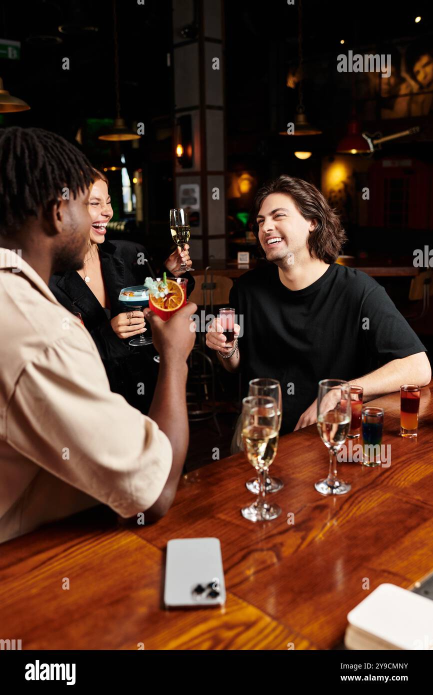 A diverse group of young colleagues enjoys drinks and laughter at a ...