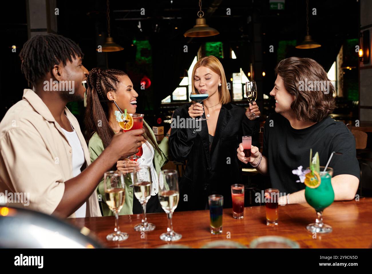 Colleagues celebrate together, sharing laughs and cocktails at a lively ...