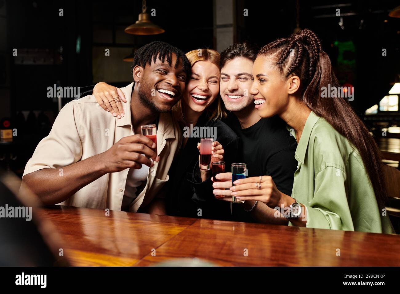 Diverse colleagues joyfully share drinks and laughter during a vibrant ...