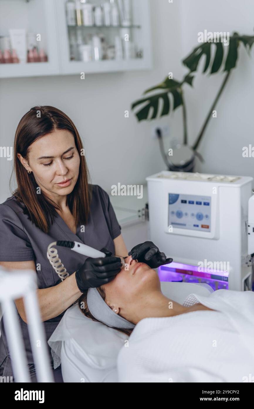 A professional female cosmetologist performs a HydraFacial procedure at ...