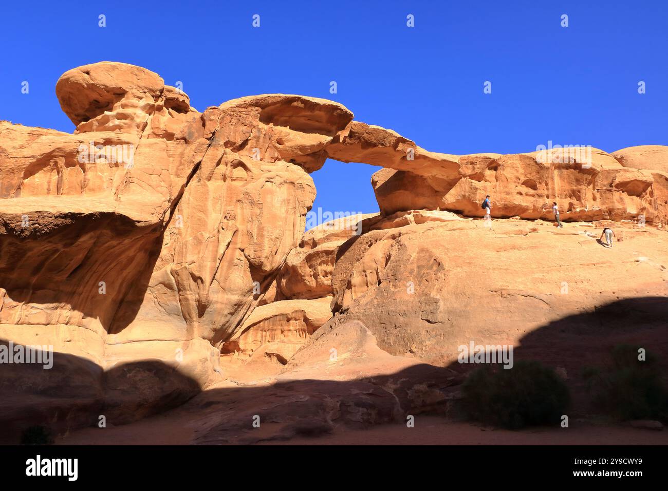 Wadi Rum in Jordan - May 15 2024: people climb up the Jebel Burdah rock ...