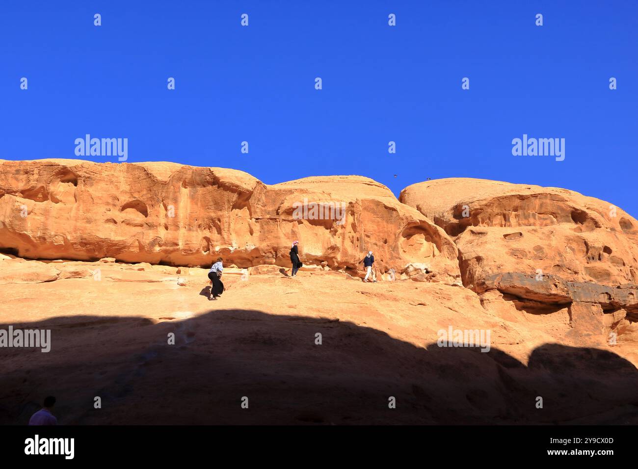Wadi Rum in Jordan - May 15 2024: people climb up the Jebel Burdah rock ...