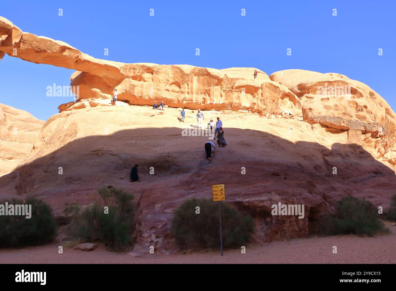 Wadi Rum in Jordan - May 15 2024: people climb up the Jebel Burdah rock ...