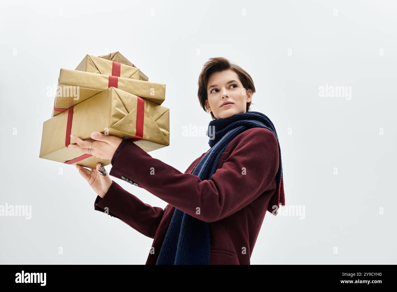 The beautiful woman dons an elegant winter outfit while holding festive ...