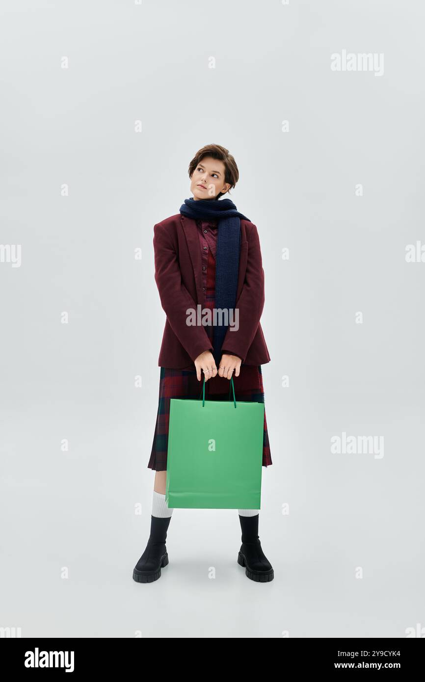 The cozy clad woman stands confidently, holding a vibrant green bag ...