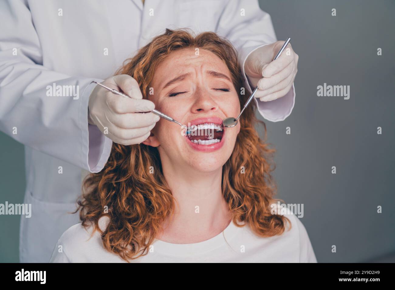 Photo of professional dentist examining teeth of afraid and scared ...