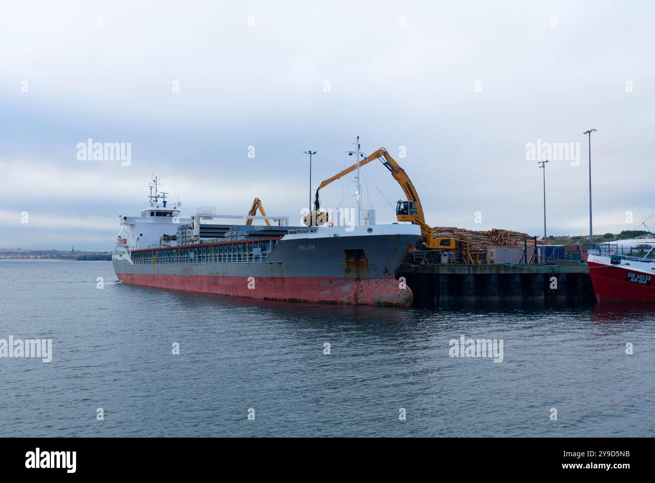 Loading logs onto cargo ship, Scrabster, North Scotland Stock Photo - Alamy