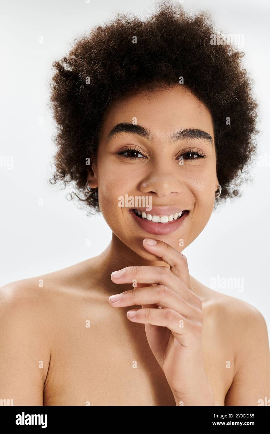 A joyful young woman poses with a thoughtful smile, showcasing her ...