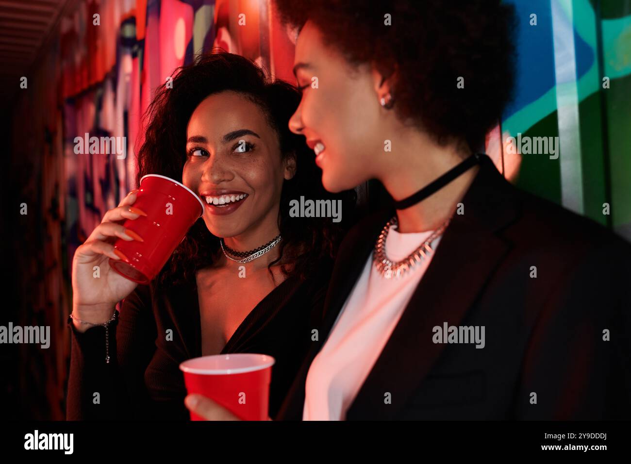 Friends share laughter and drinks in a lively urban setting ...