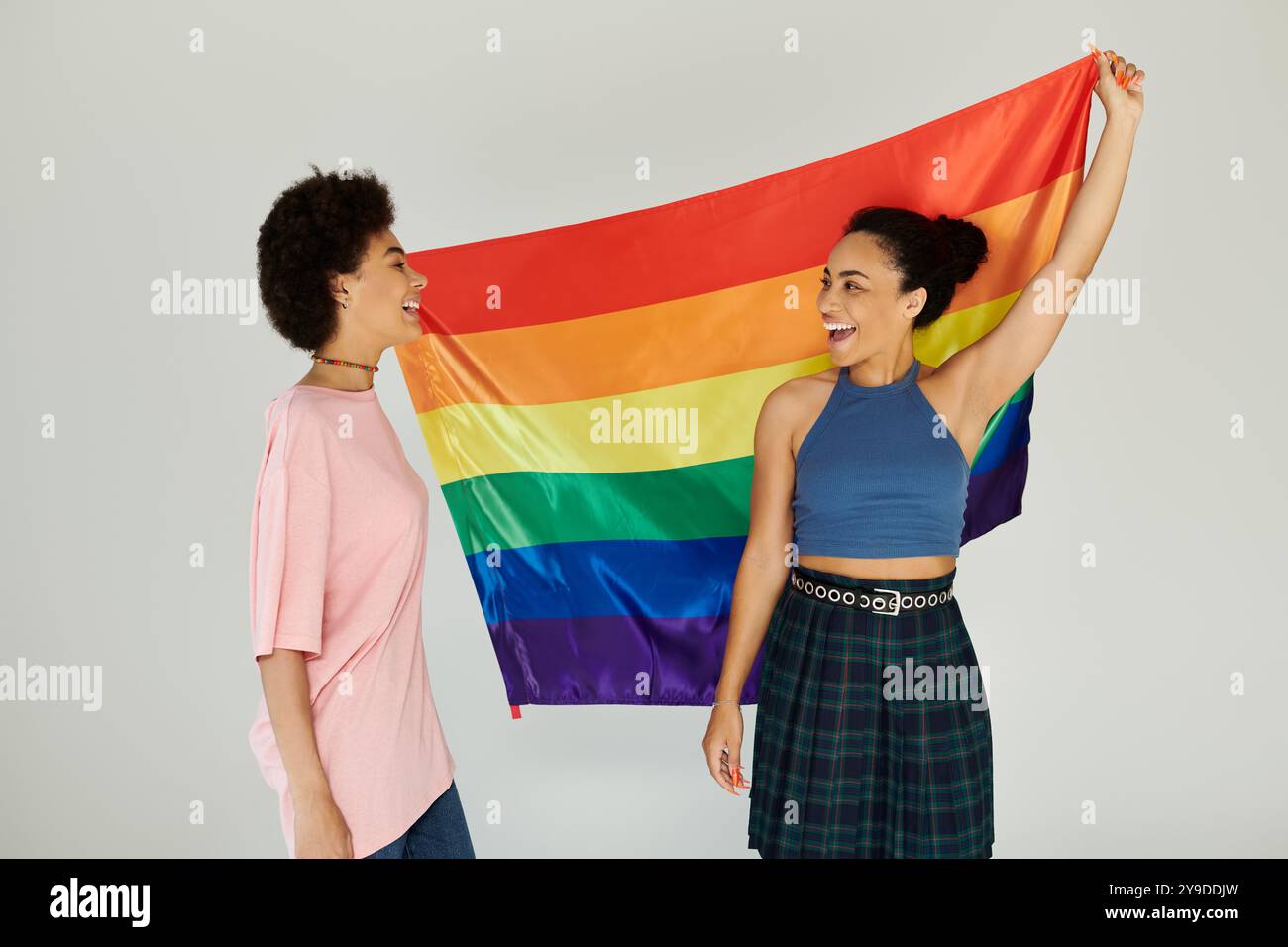 Two friends joyfully express their pride while holding a vibrant ...