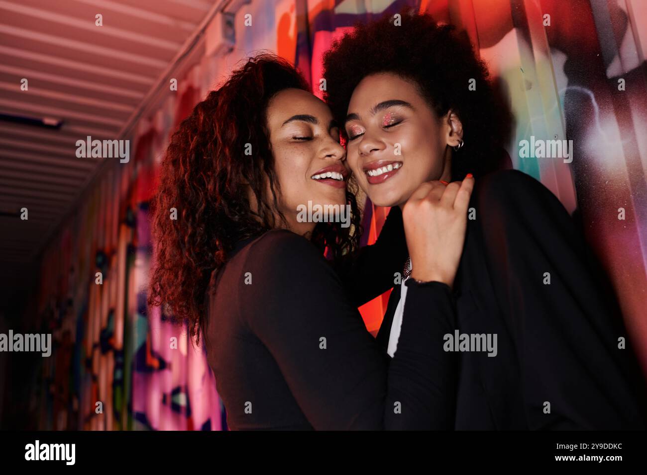 Two friends joyfully share a moment together, surrounded by colorful ...