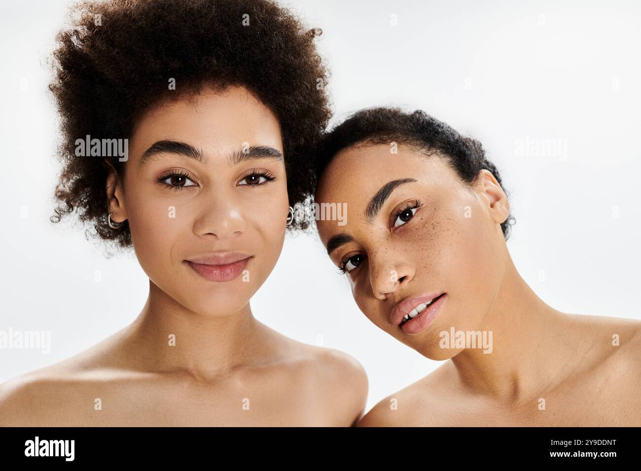 Two friends share a joyful moment, showcasing their natural beauty in a ...